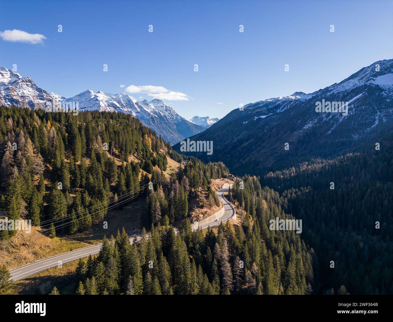 Snowy mountain peaks tower above a road, encircled by majestic ...