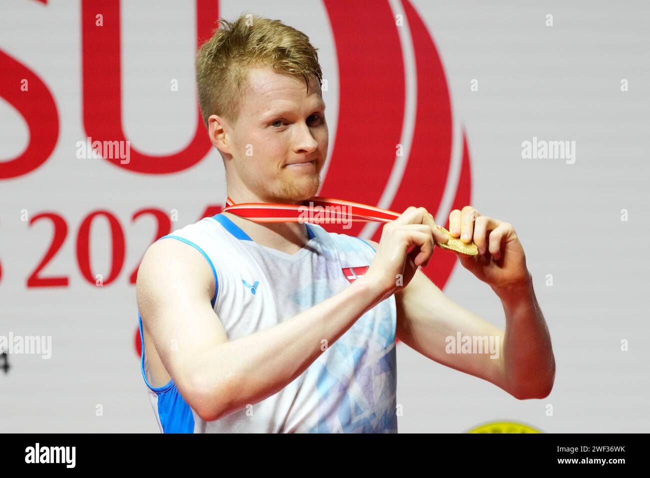 Denmark's Anders Antonsen celebrates on the podium after defeating ...