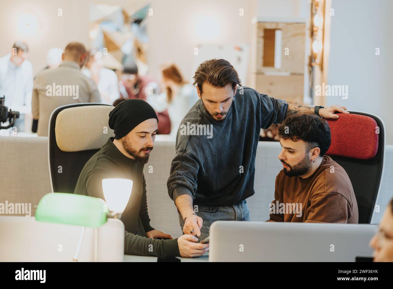 A collaborative workplace atmosphere between multiracial people is ...