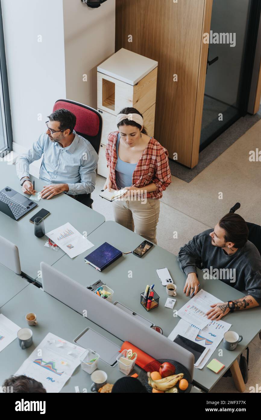 Overhead view of a different aged team engaging in a collaborative ...