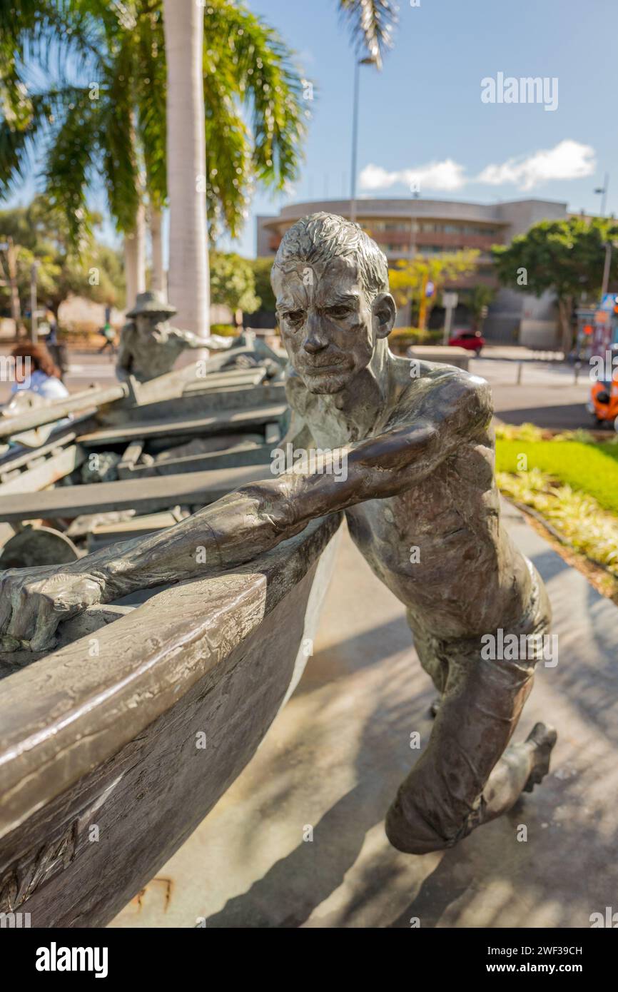 a bronze statue of a male fisherman pushing a small fishing boat ...