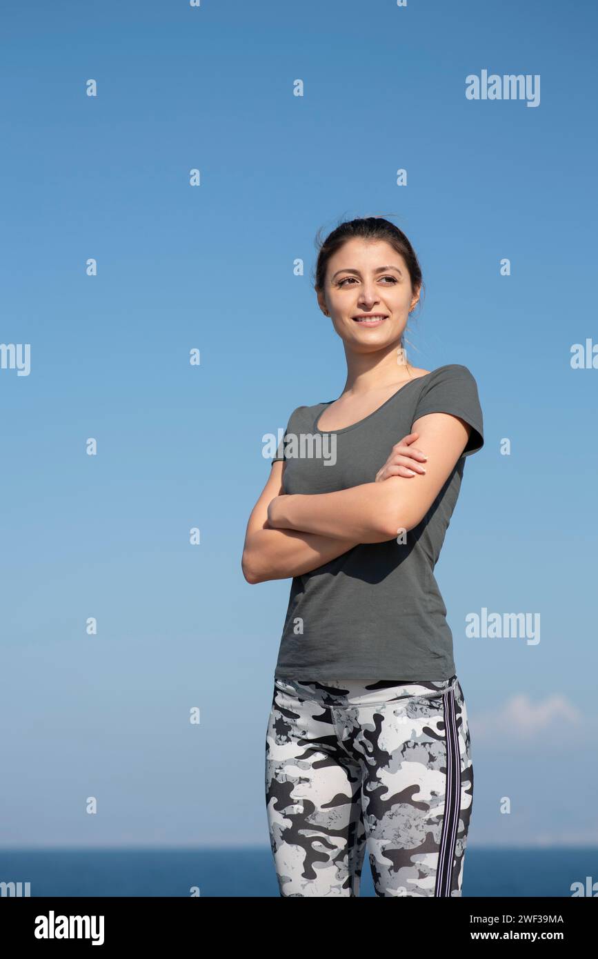 Beautiful woman arms folded looking away smiling outdoors Stock Photo ...