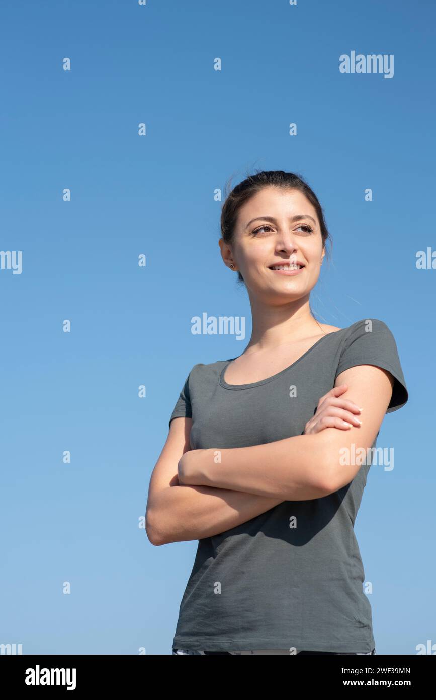 Beautiful woman arms folded looking away smiling outdoors Stock Photo ...