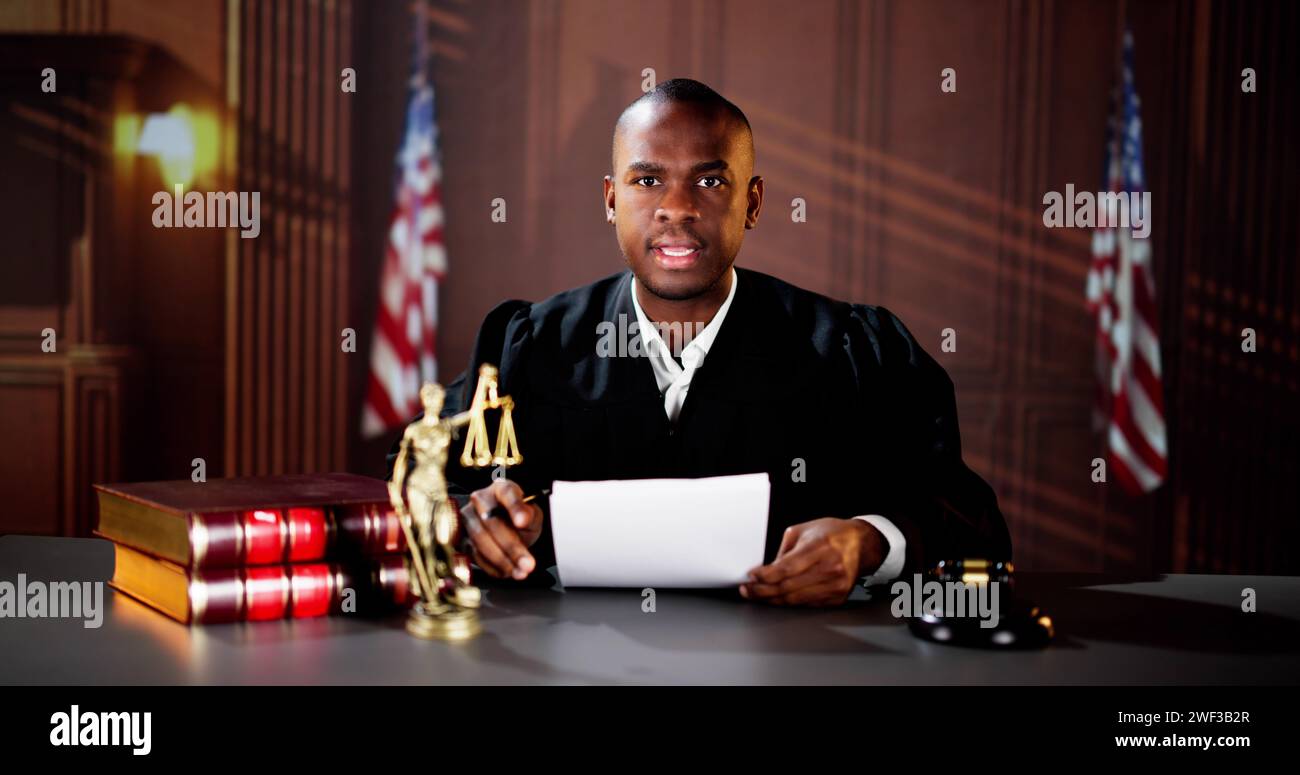 Male Judge Reading Documents While Sitting At Desk In Courtroom Stock ...