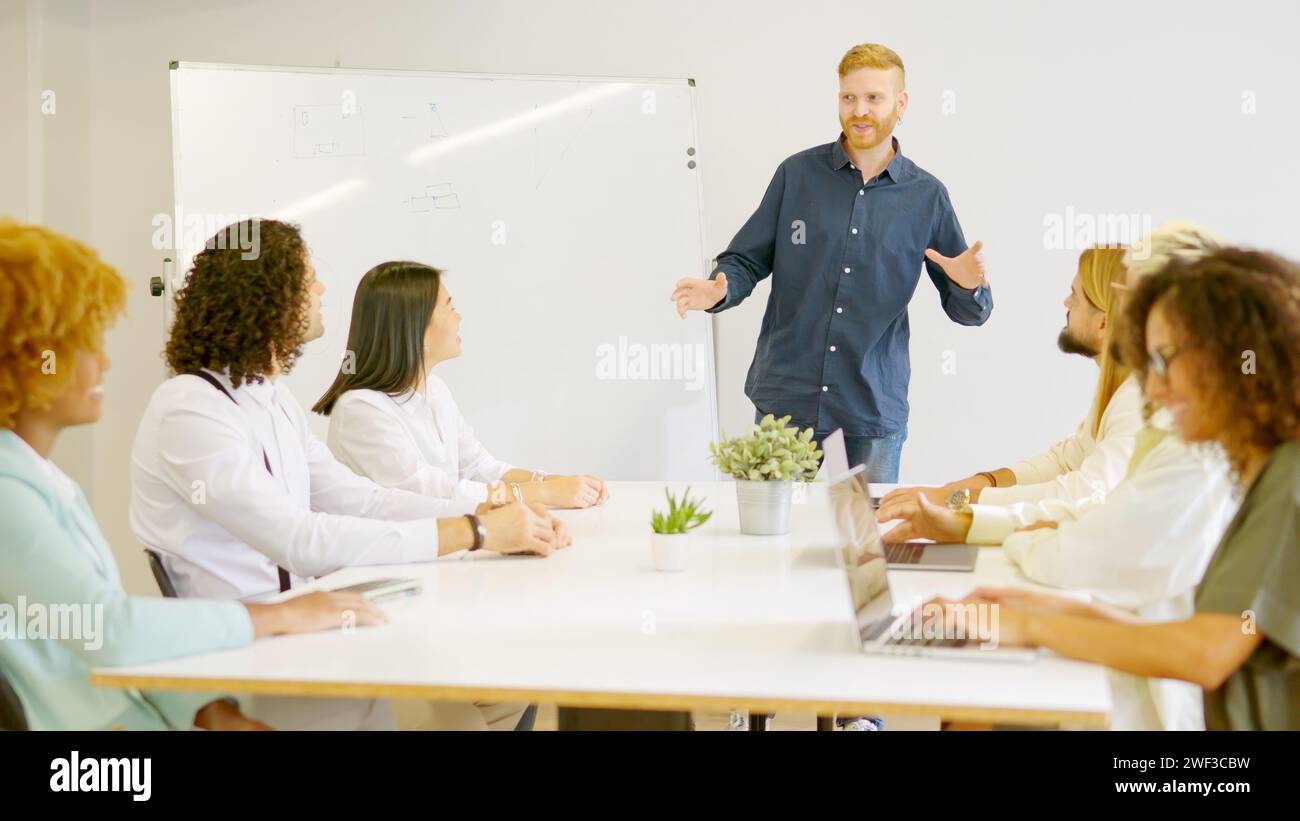 Man leading a meeting in a coworking using a board Stock Photo - Alamy