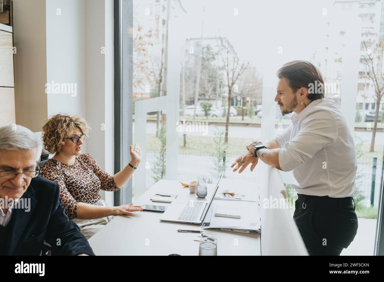 Multi generational coworkers discussing business strategies in a modern ...