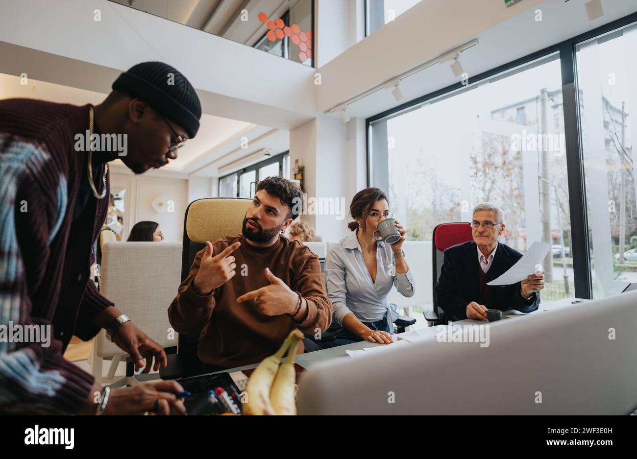 A multicultural business team engages in a discussion in a well-lit ...