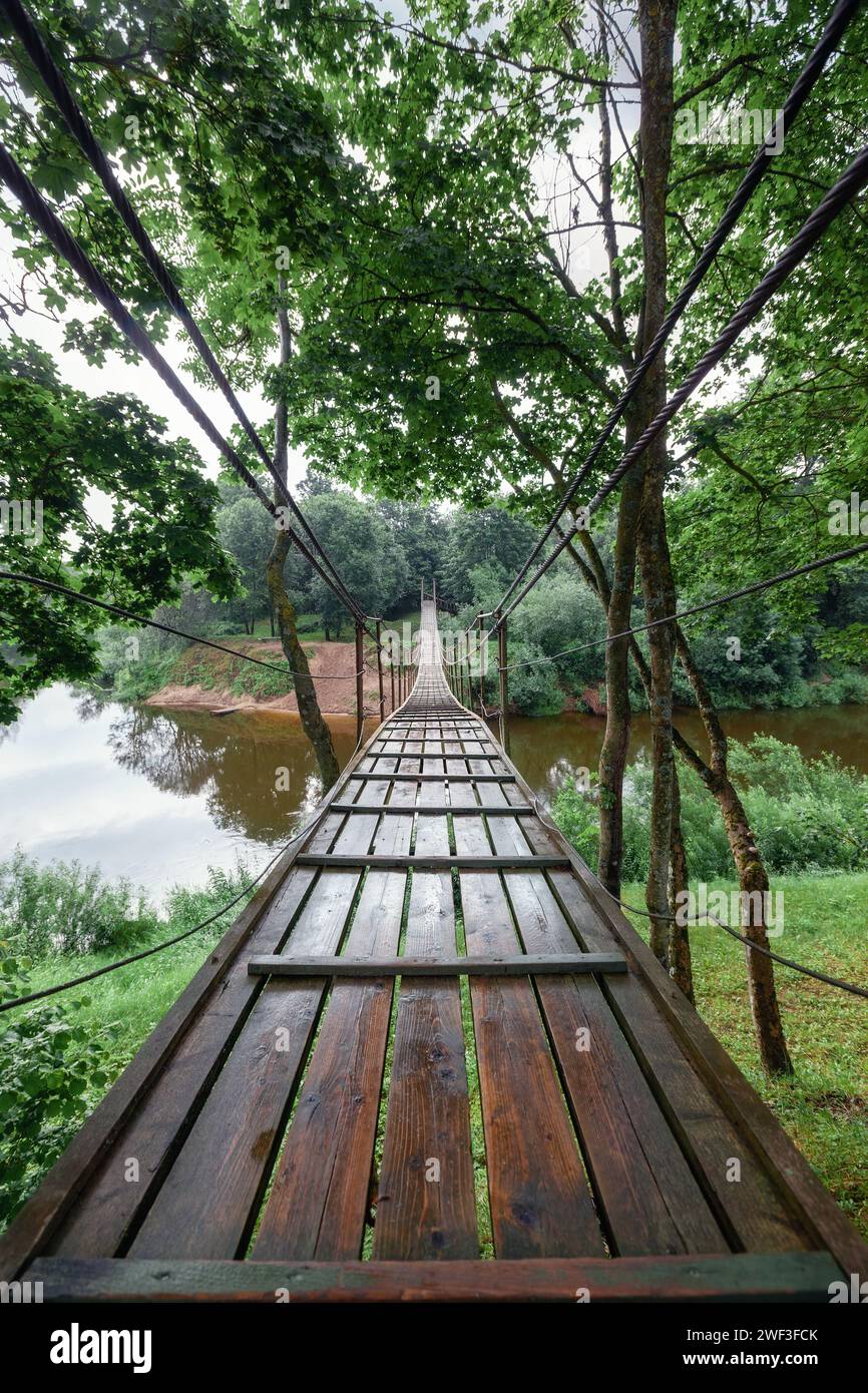 Hanging monkey bridge over the Minija river in Lithuania. Shot from a ...