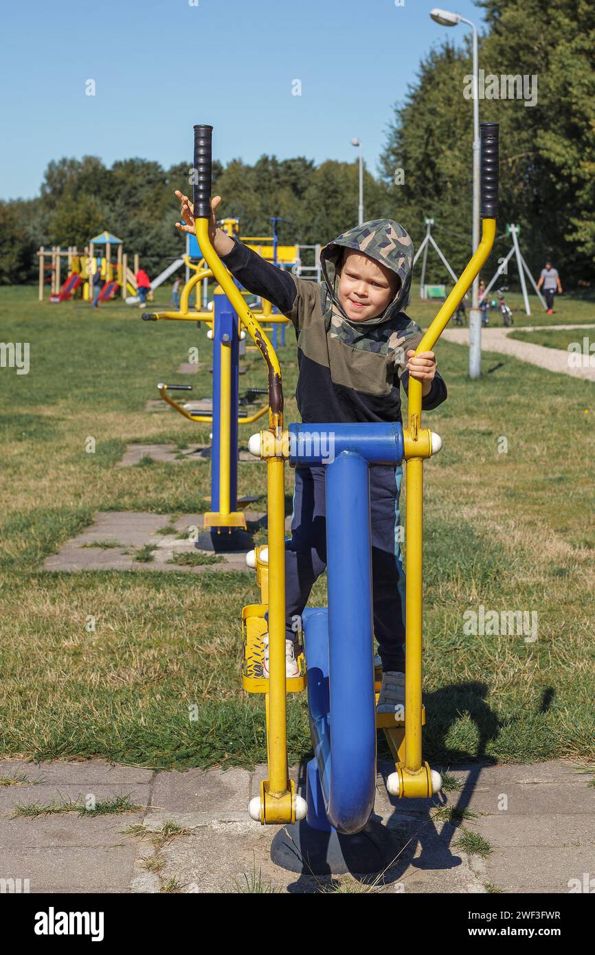 Happy little child playing on outdoor elliptical trainer Stock Photo ...