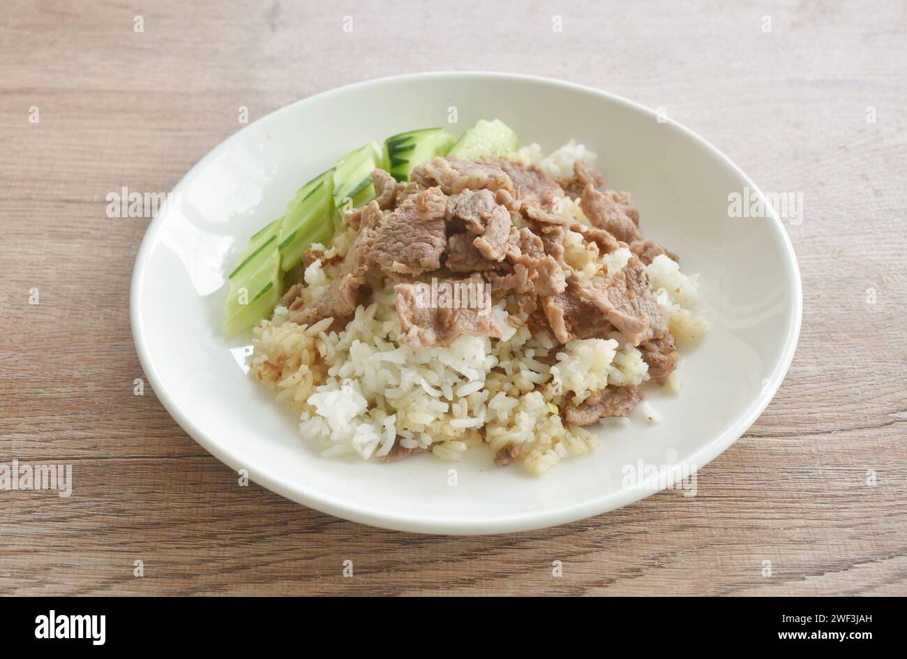 fried salty slice beef meat with garlic and pepper on rice in plate ...