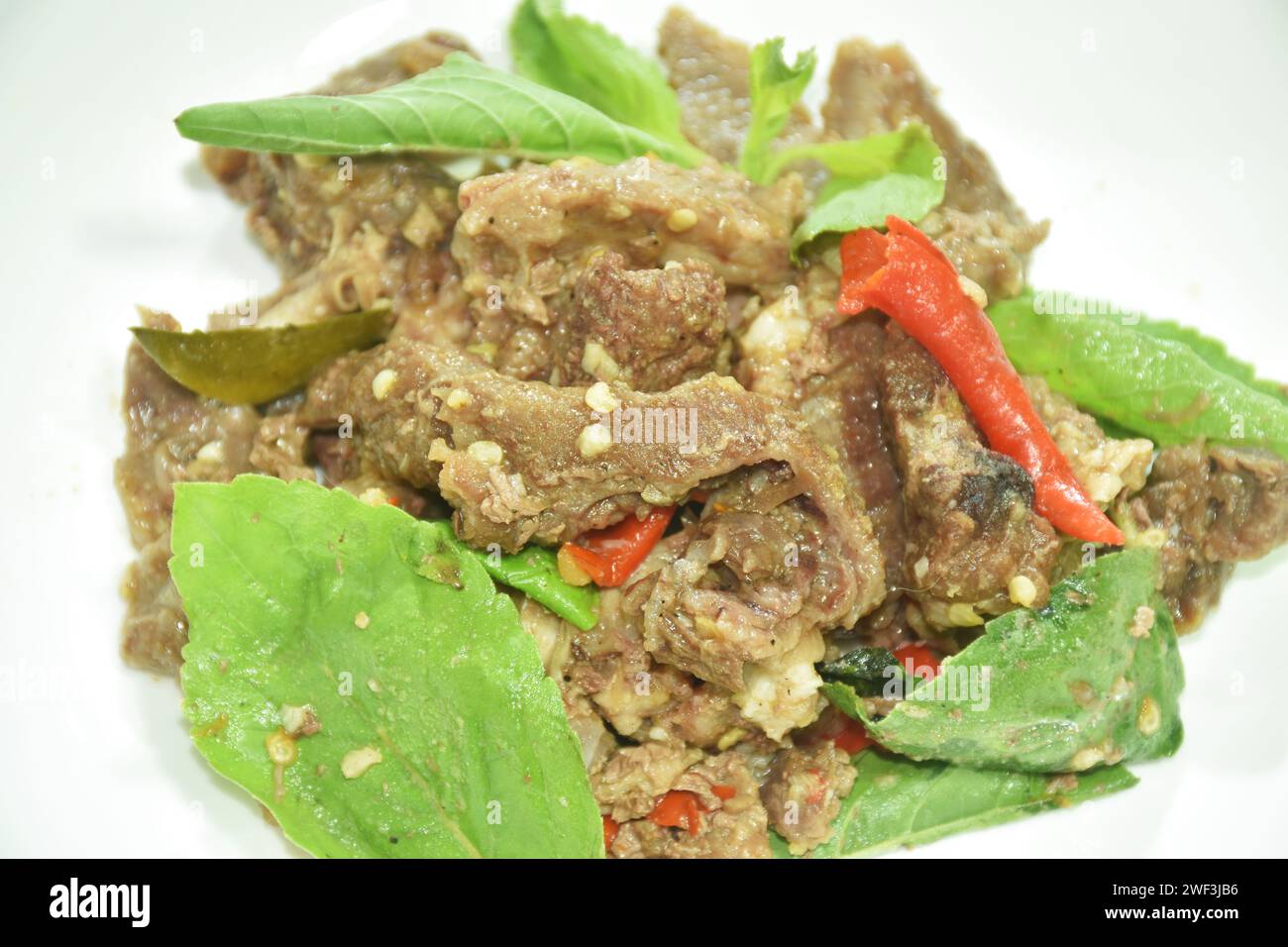 spicy stir fried slice braised beef meat with basil leaf and chili on ...