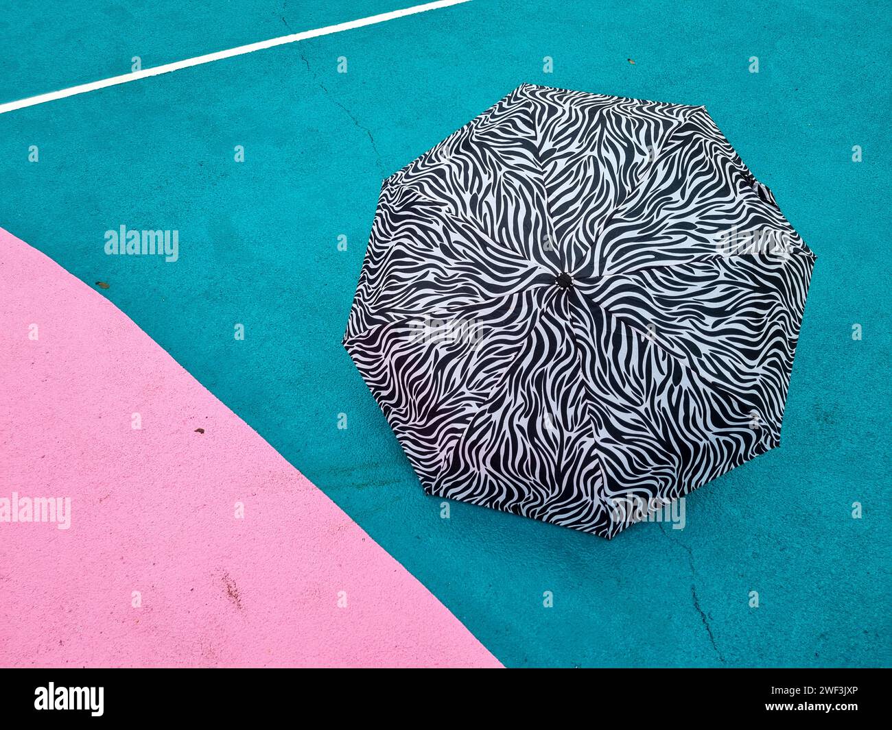 An umbrella resting atop a vibrant tennis court Stock Photo - Alamy