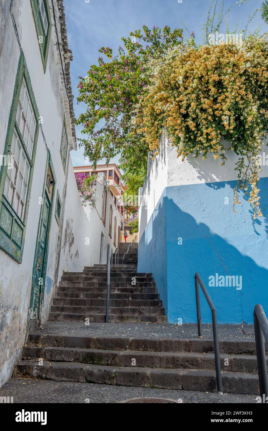Narrow passage between white painted rendered buildings with steep ...