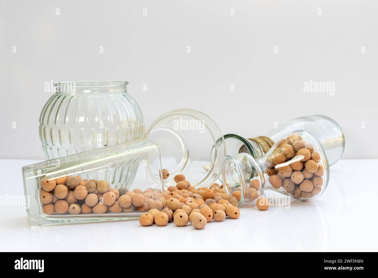 Lightwieght expanded aggregate balls with glass pots and vases on white ...