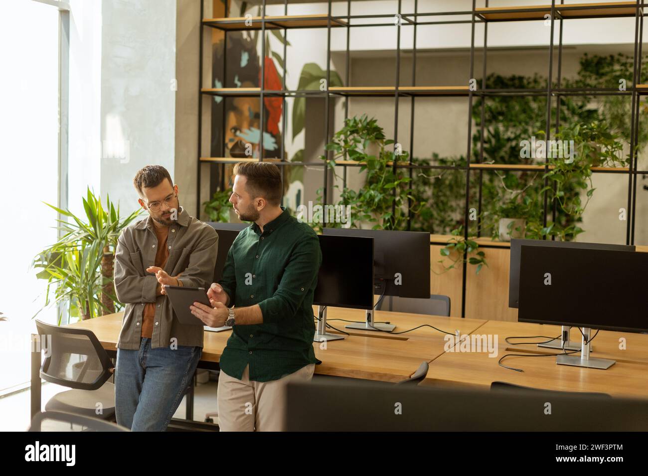 Two professionals are engaged in a focused conversation while holding ...