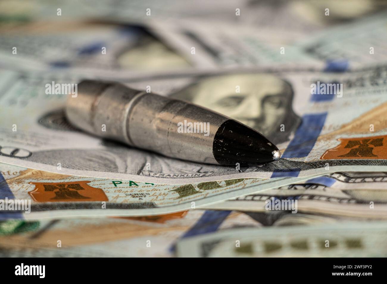 Hundred dollar bills and armor piercing bullet, business, finance and ...