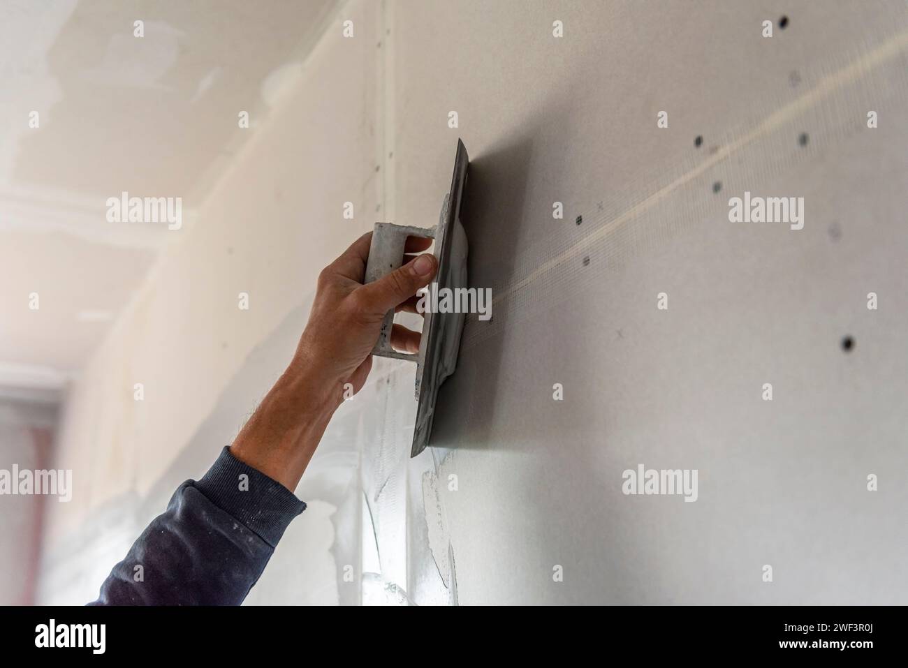old manual worker with wall plastering tools renovating house ...