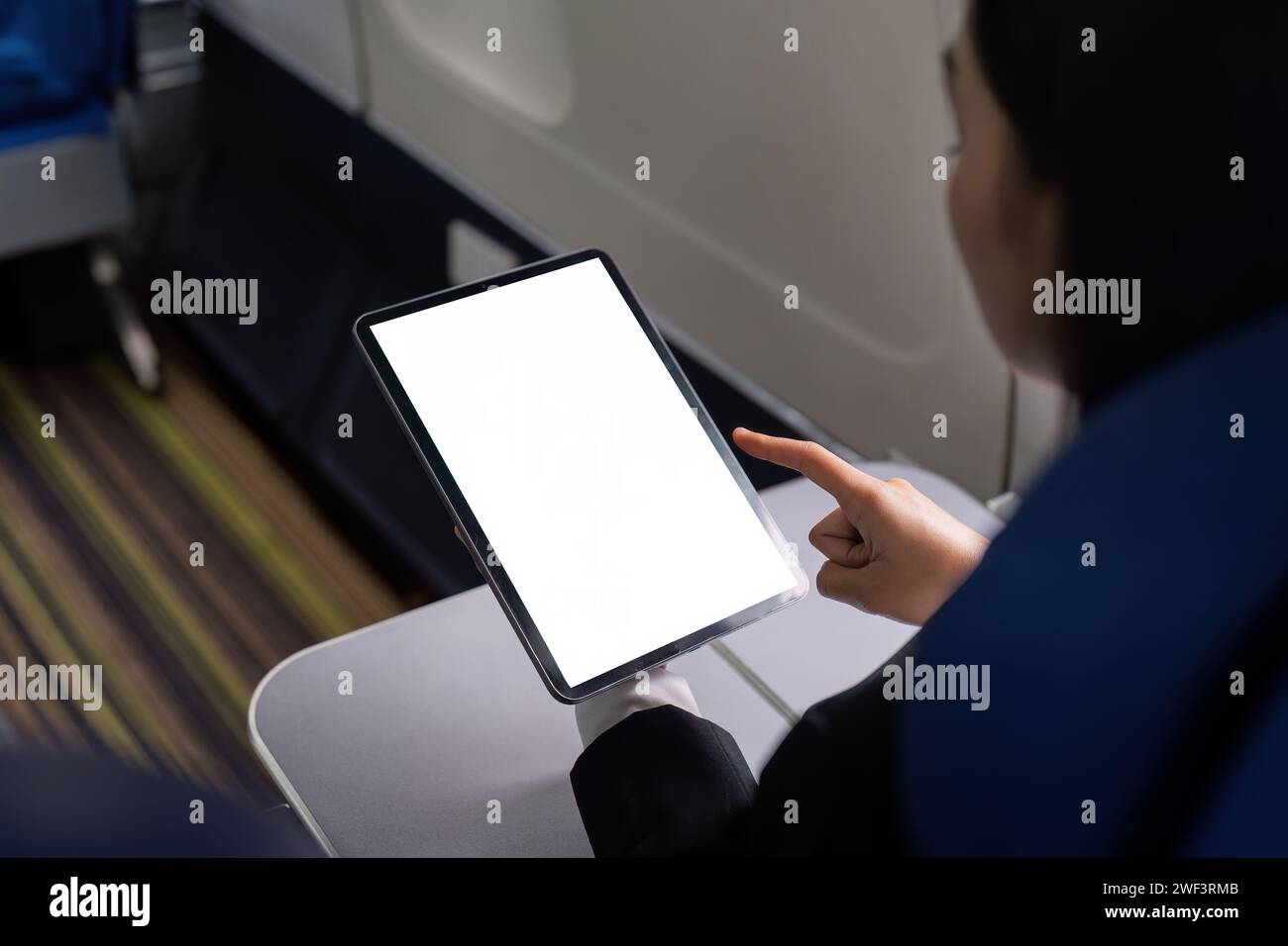 Woman traveler or passenger sits at the window seat, using his portable ...
