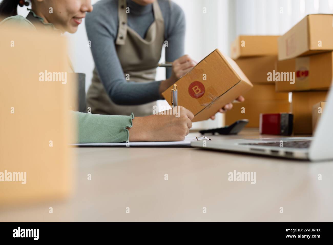 Asian woman write parcel box to prepare for delivery to customer. e ...