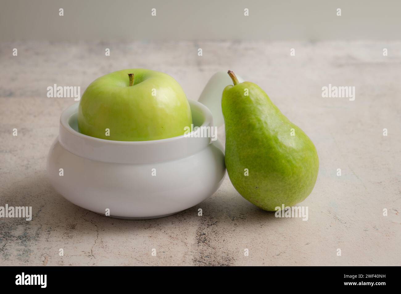 A pear and an apple on a kitchen counter Stock Photo - Alamy