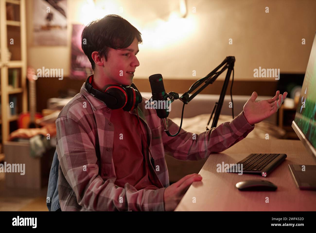 Side view portrait of teenage boy speaking to microphone while live ...