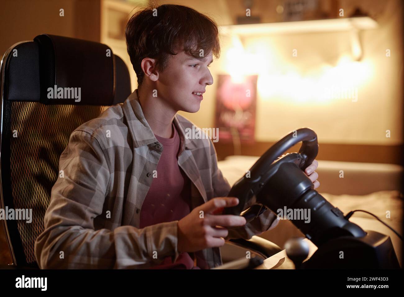 Side view portrait of young teenage boy playing racing simulator ...