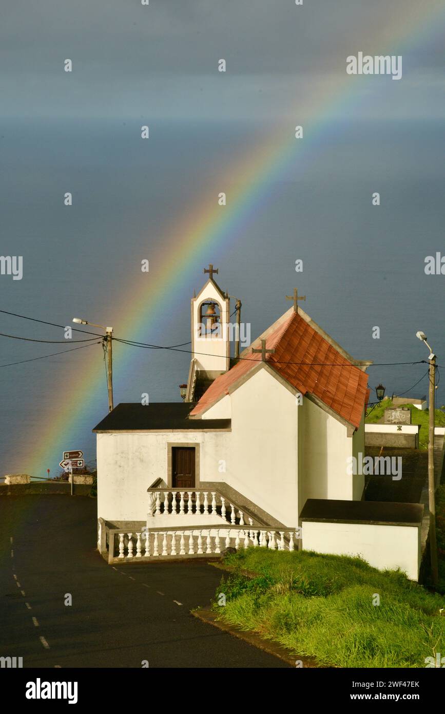 Spectacular cliffside view over ocean with rainbow at Miradouro da Boa Morte, near church and ...