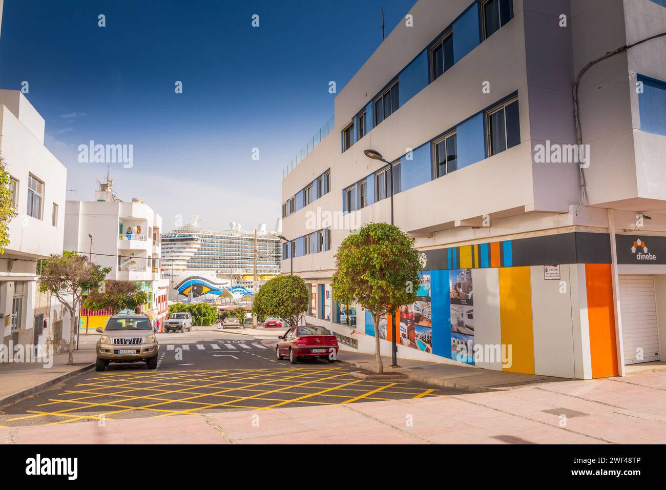 Bright colourful Spanish street and with the Aida Cosma cruise liner ...
