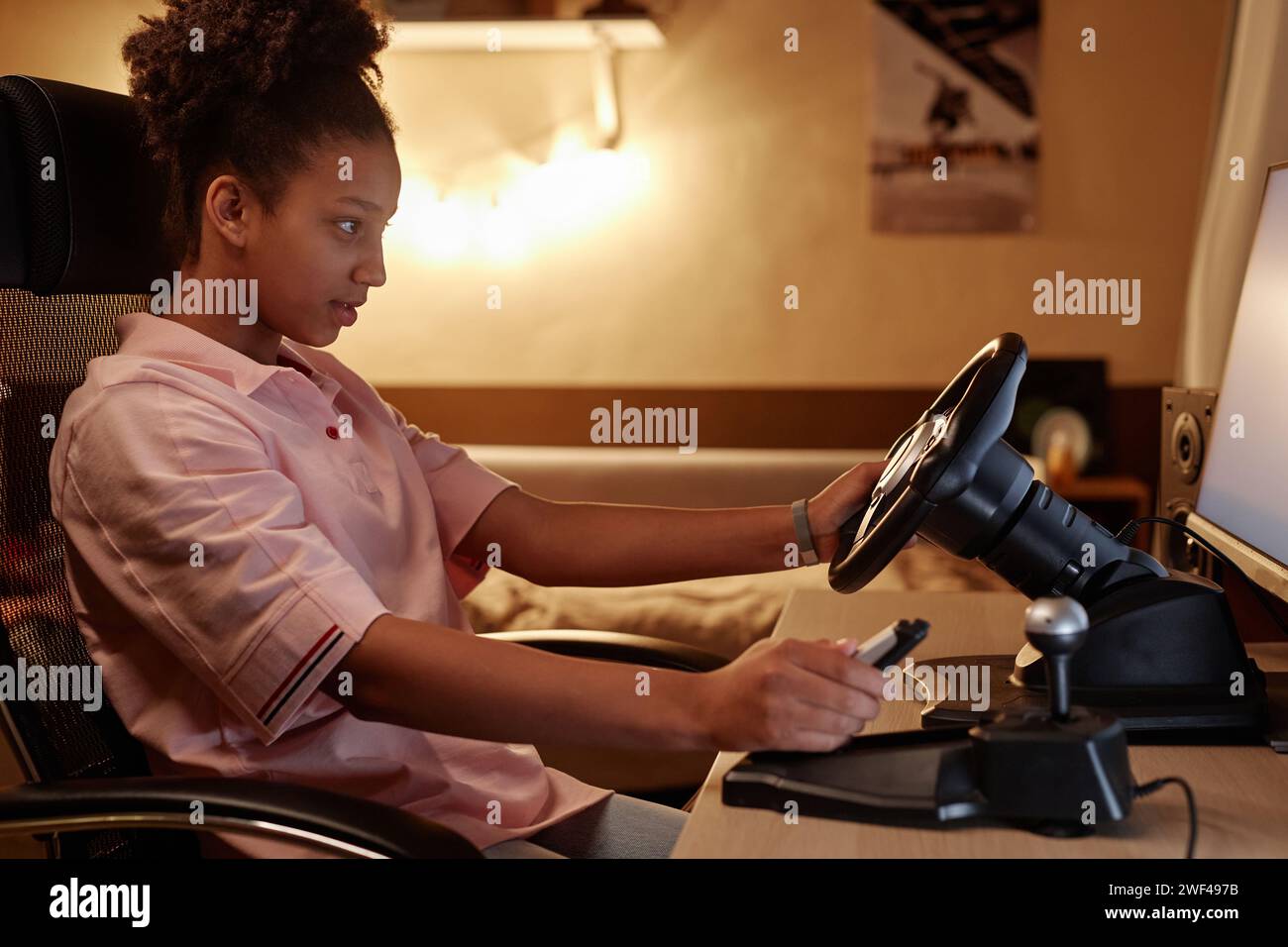 Side view portrait of Black teenage girl playing racing simulator ...