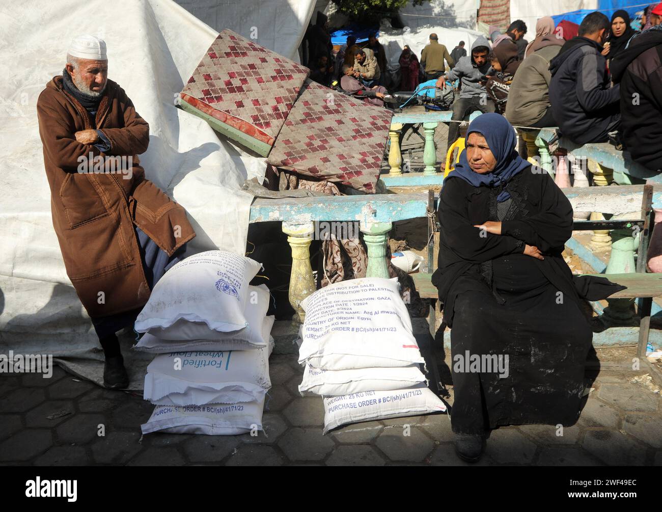 Displaced Palestinians receive bags of flour at the United Nations ...
