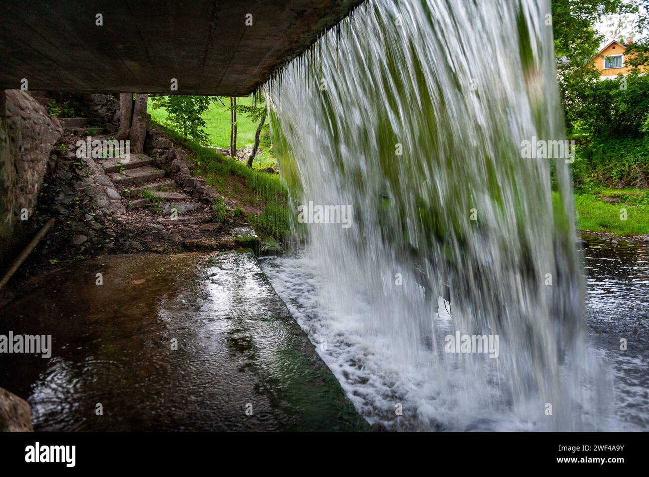 Passage under an artificial waterfall. Wall of water, falling cascade ...