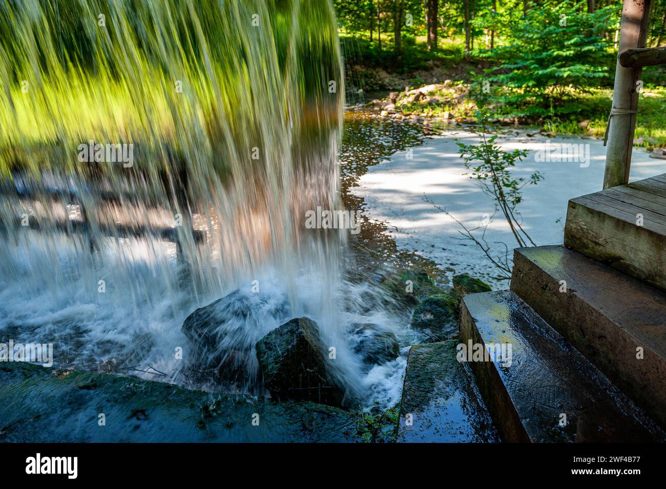 Passage under an artificial waterfall. Wall of water, falling cascade ...