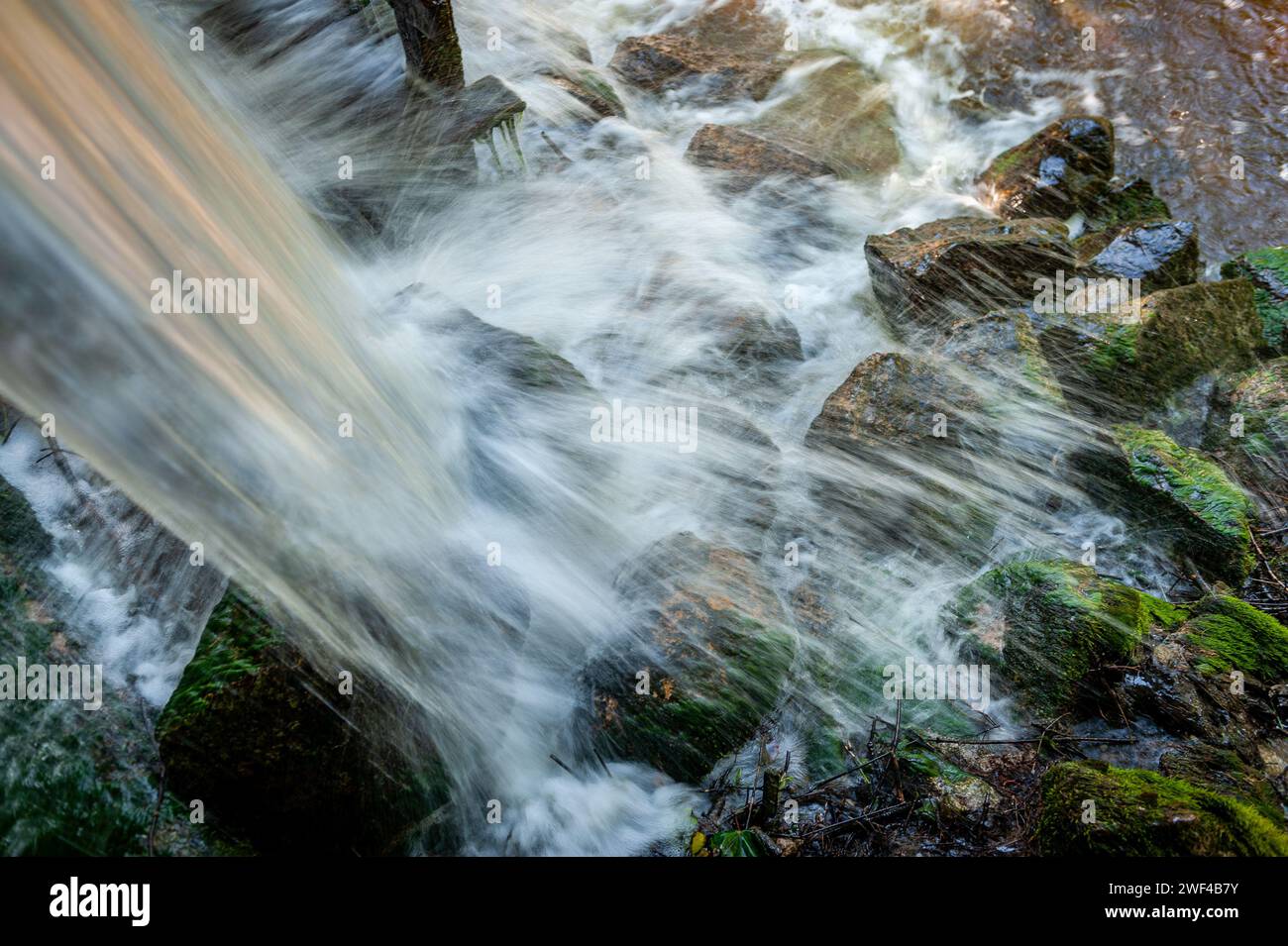Water splashing from impact onto rocks. Stream of clean falling water ...