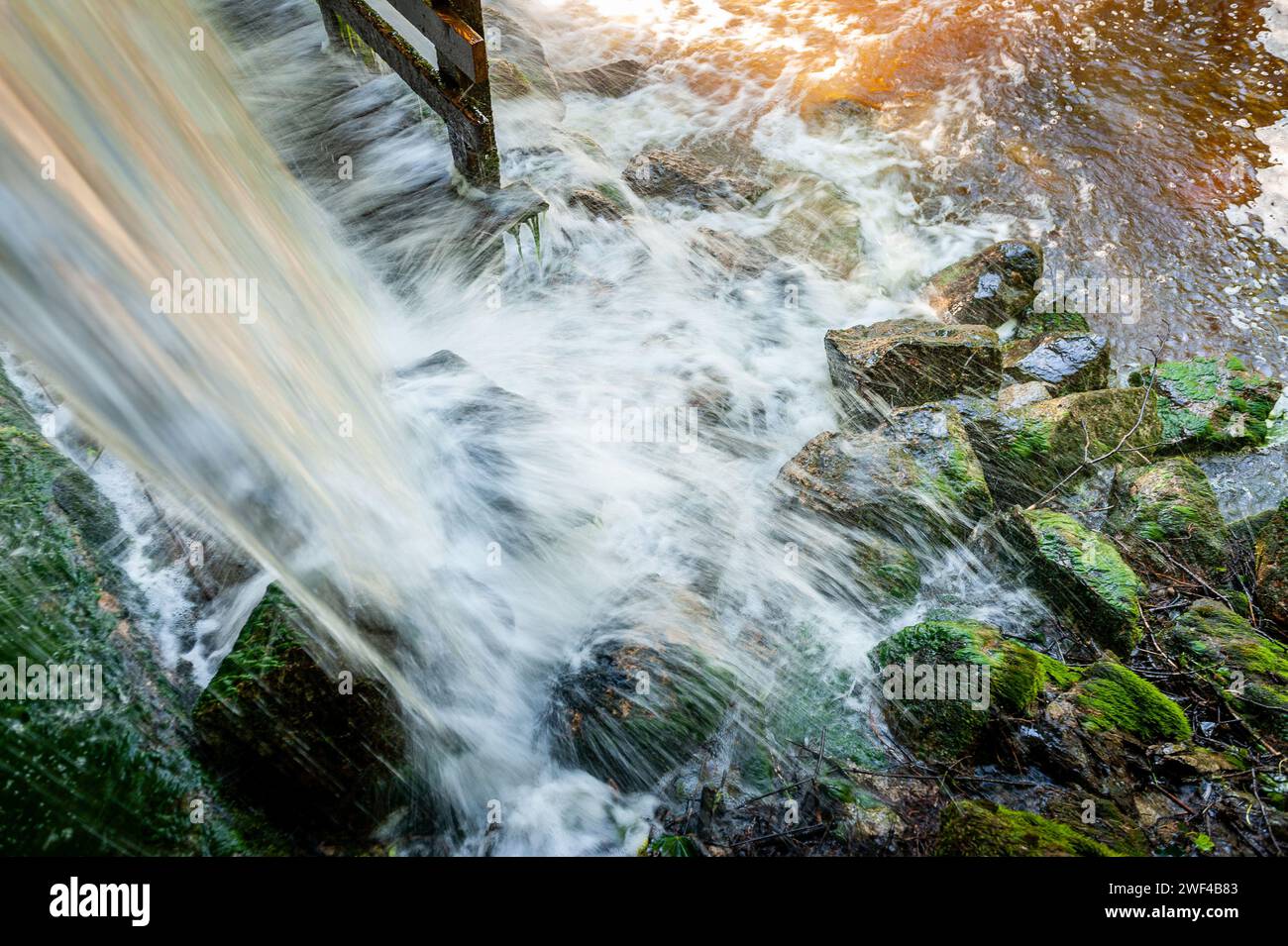Water splashing from impact onto rocks. Stream of clean falling water ...