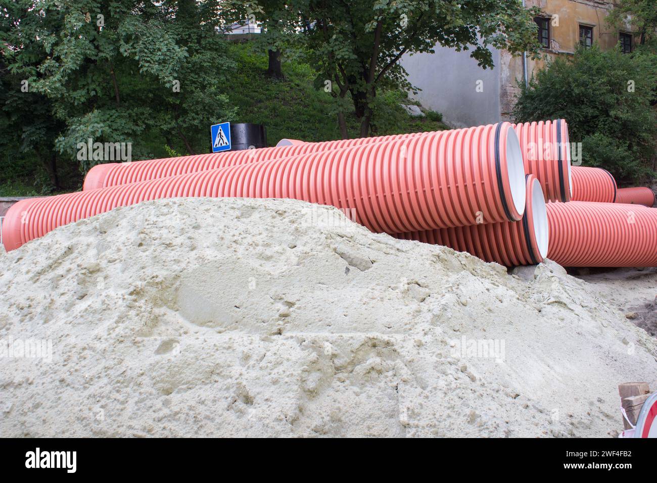 large sewage pipes on the sand lie in the city Stock Photo - Alamy