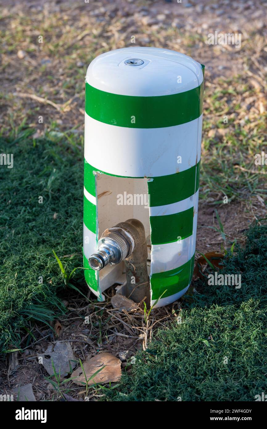 A water tap protected by an improvised green and white plastic cover ...