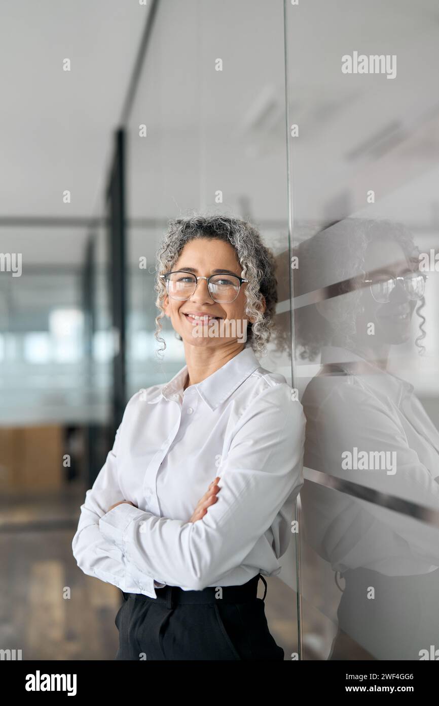 Happy middle aged professional business woman standing in office ...