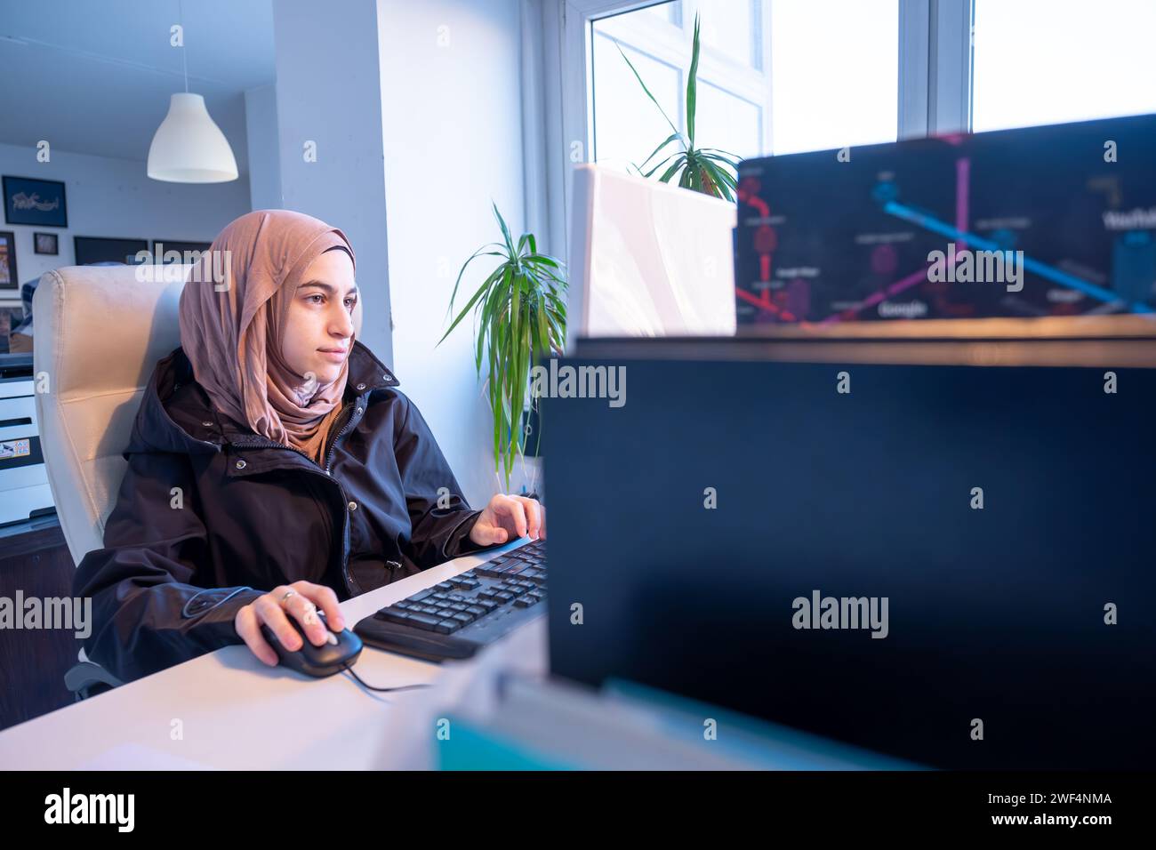 Muslim female working in office using computer with white background ...