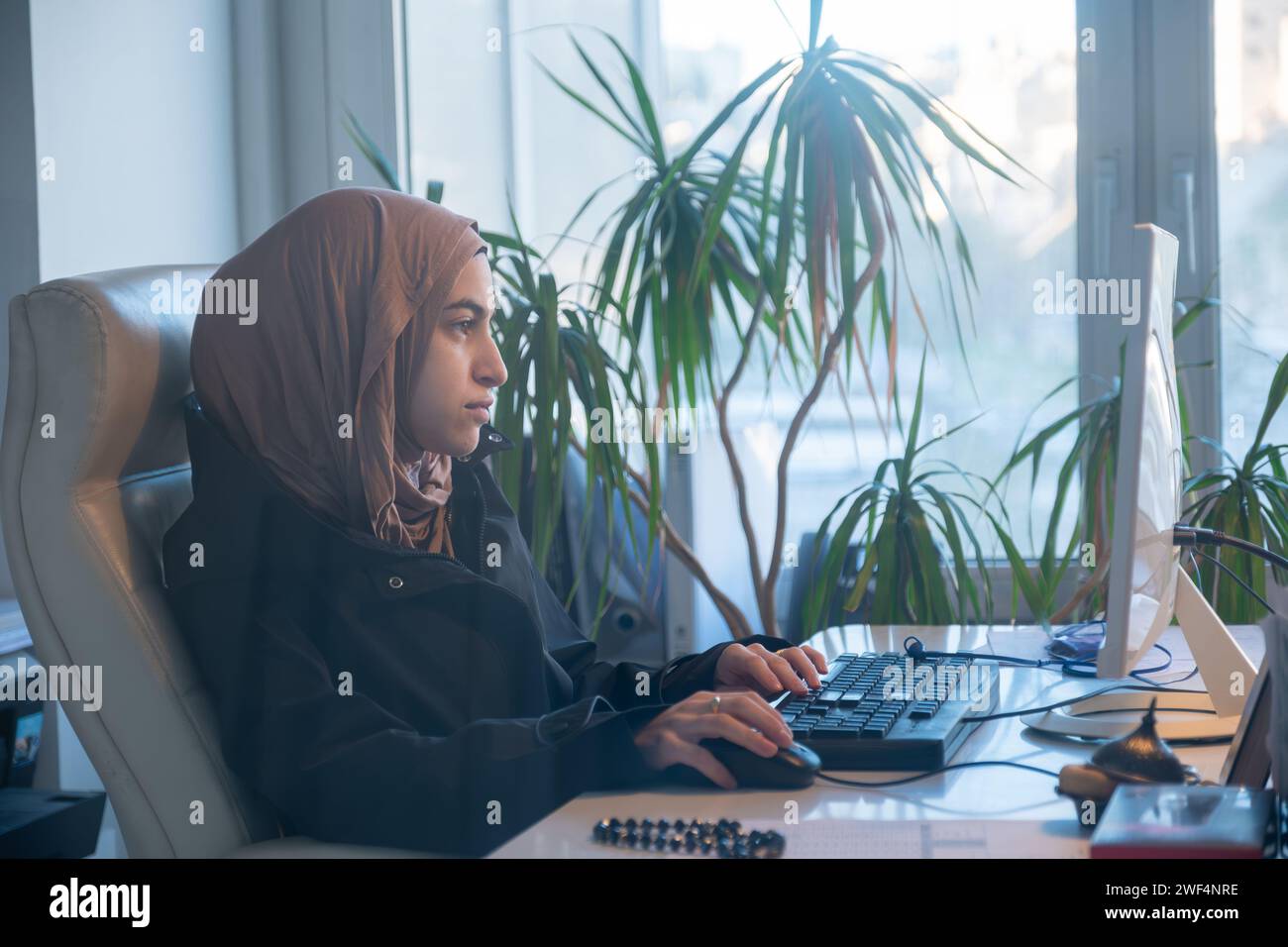 Muslim female working in office using computer with white background ...