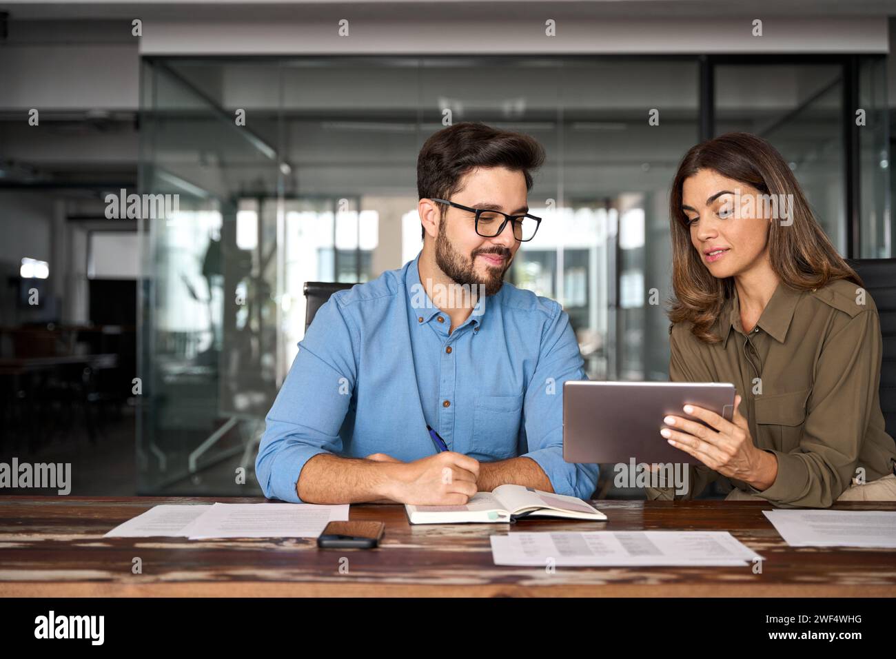 Professional happy manager showing work plan using tab helping employee ...