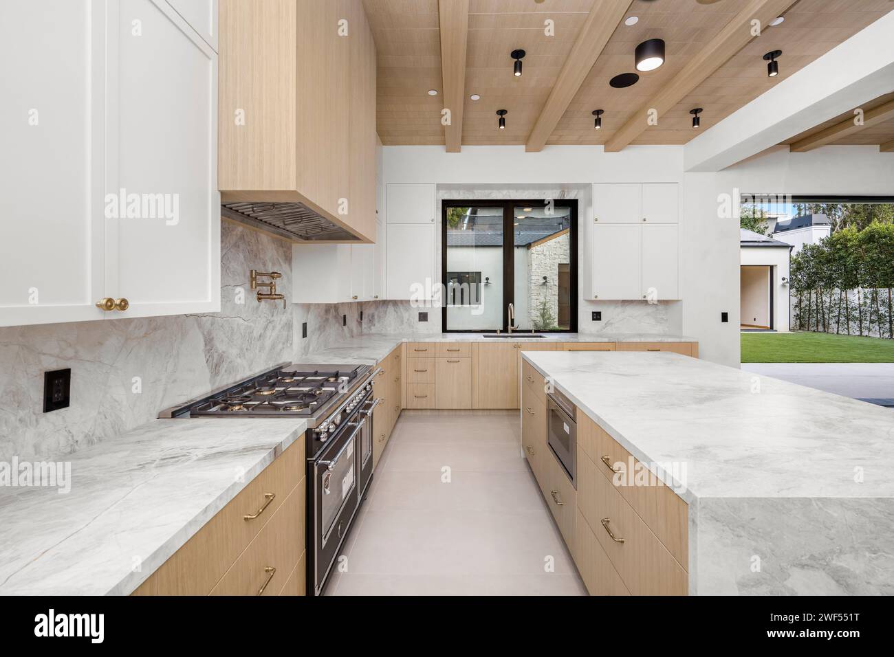 Marble countertop kitchen with backyard view through window Stock Photo ...
