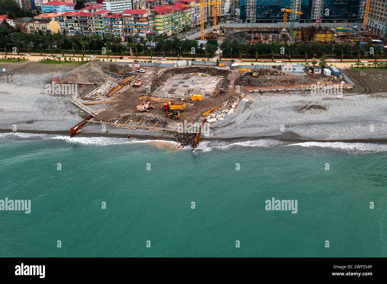Aerial view of construction site with excavators and dump trucks during ...