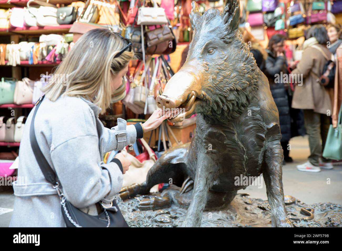 Florence, Italy. 28th Jan, 2024. A tourist puts the coin into the mouth ...