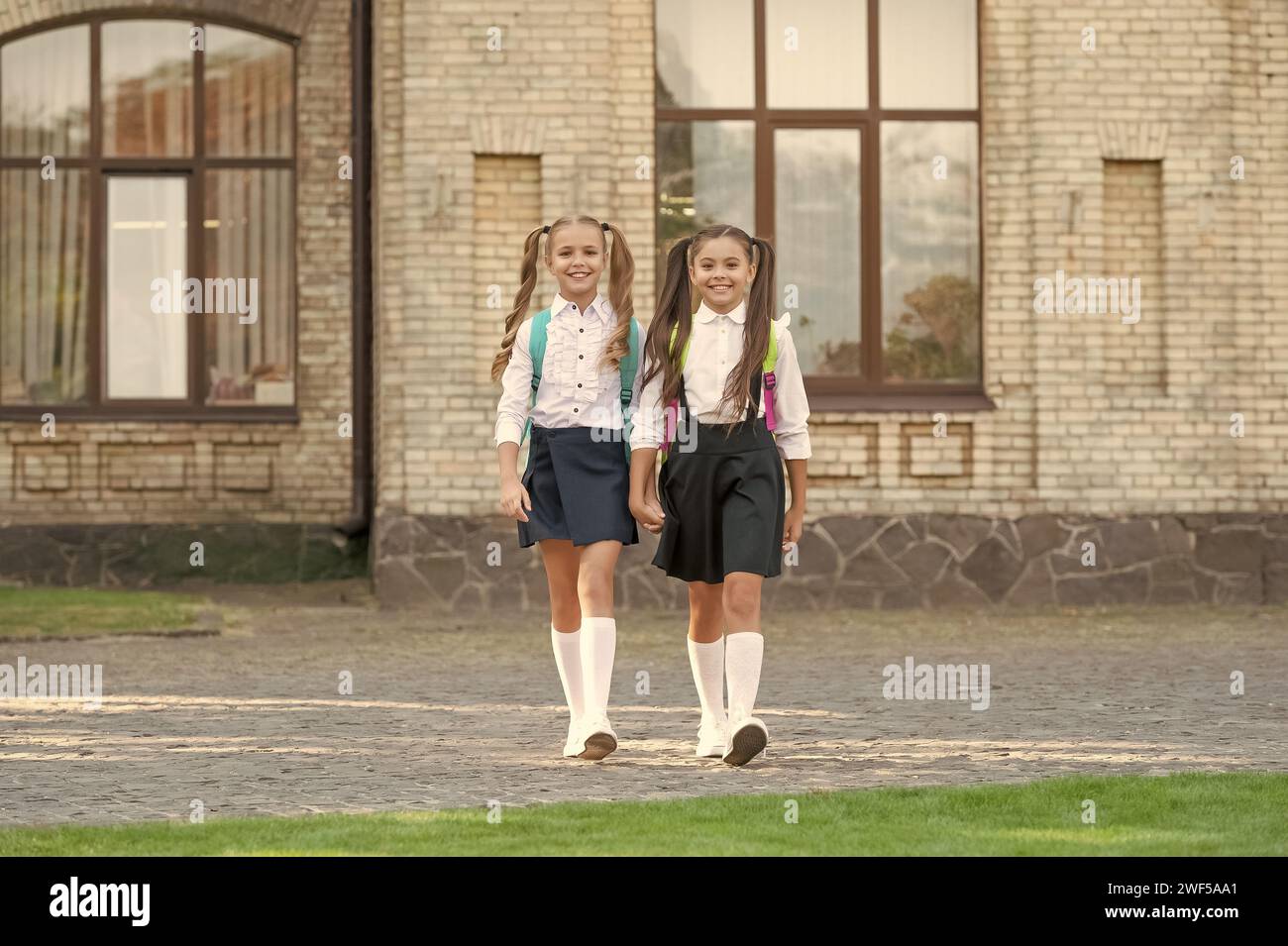 two schoolgirls in uniform walking together outdoor Stock Photo - Alamy