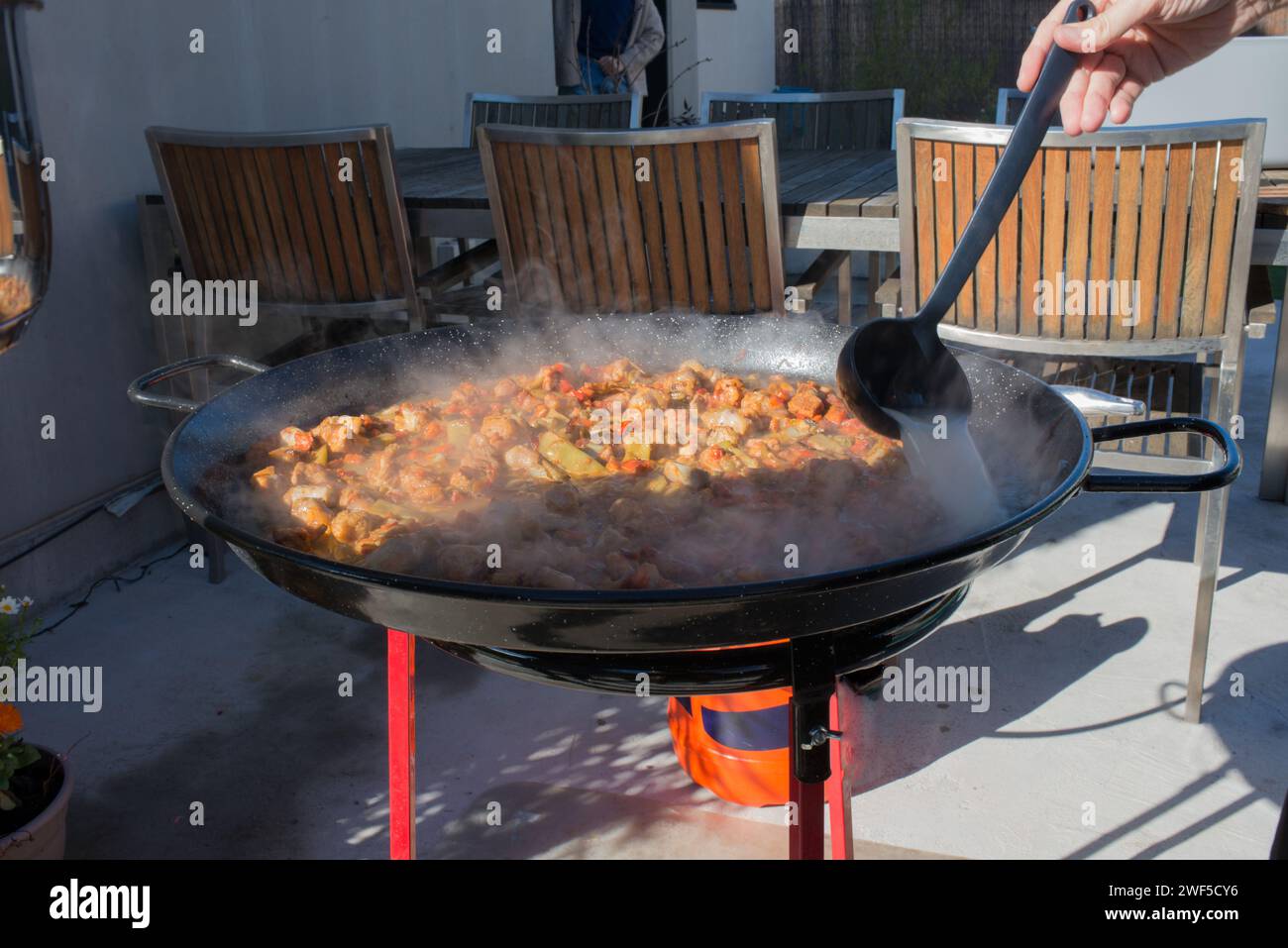 Preparing paella in the backyard. Traditional sunday meal for spanish ...