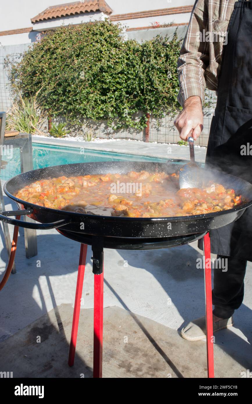 Preparing paella in the backyard. Traditional sunday meal for spanish ...