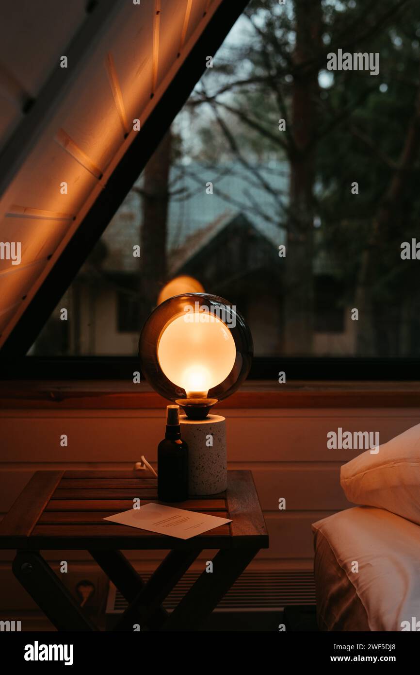 Small table with a window-lit lamp Stock Photo - Alamy