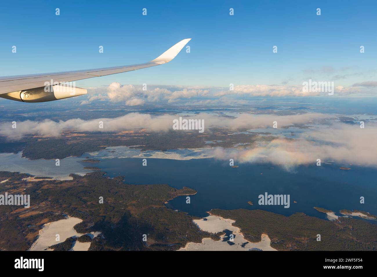 Flying above the clouds. View of clear blue sky, airplane wing and ...