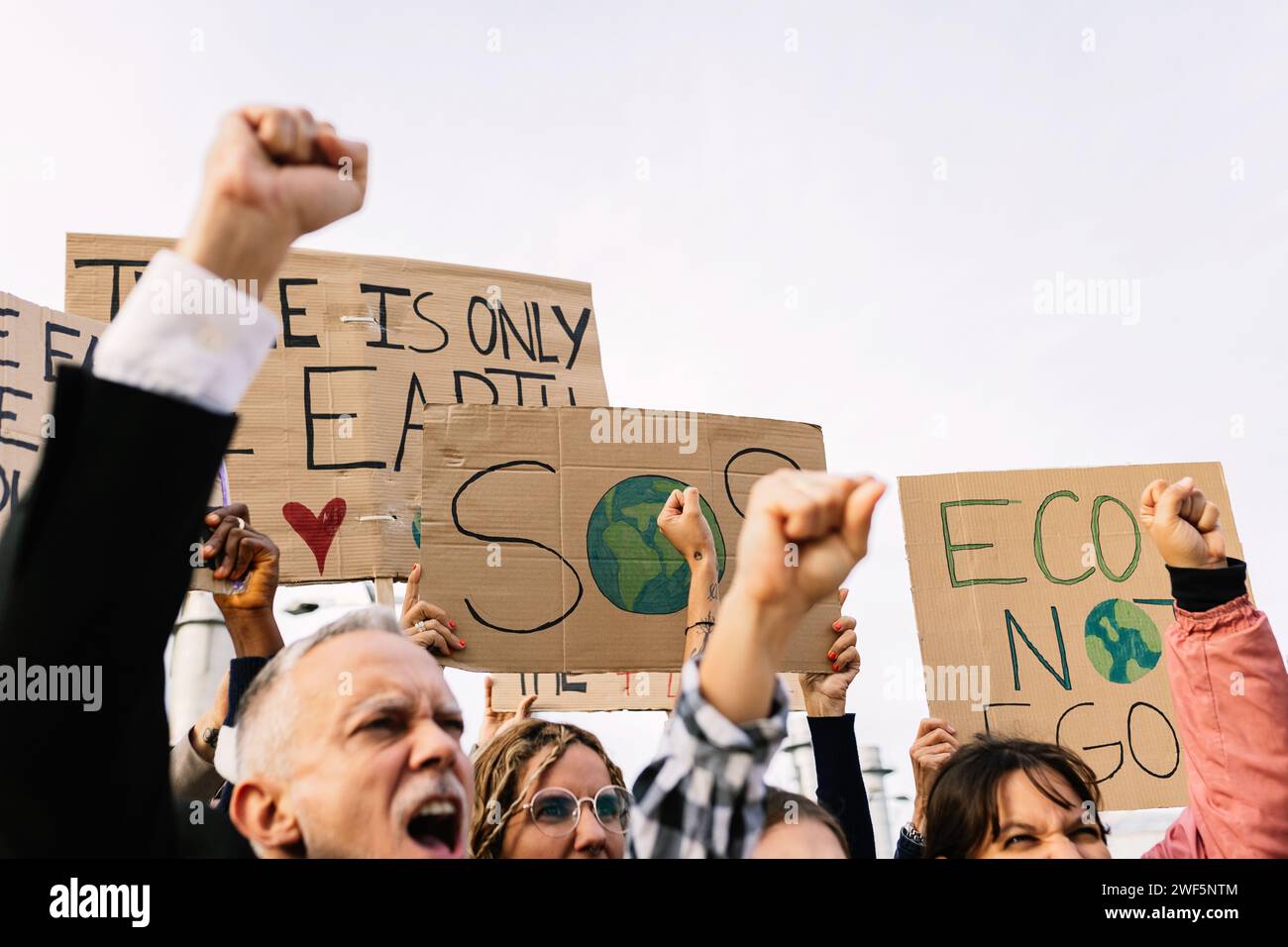 Group of different people holding posters protesting against climate ...