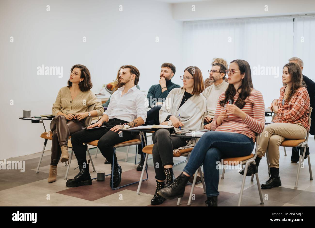 Group of attentive adults sitting in a seminar, workshop, or business ...
